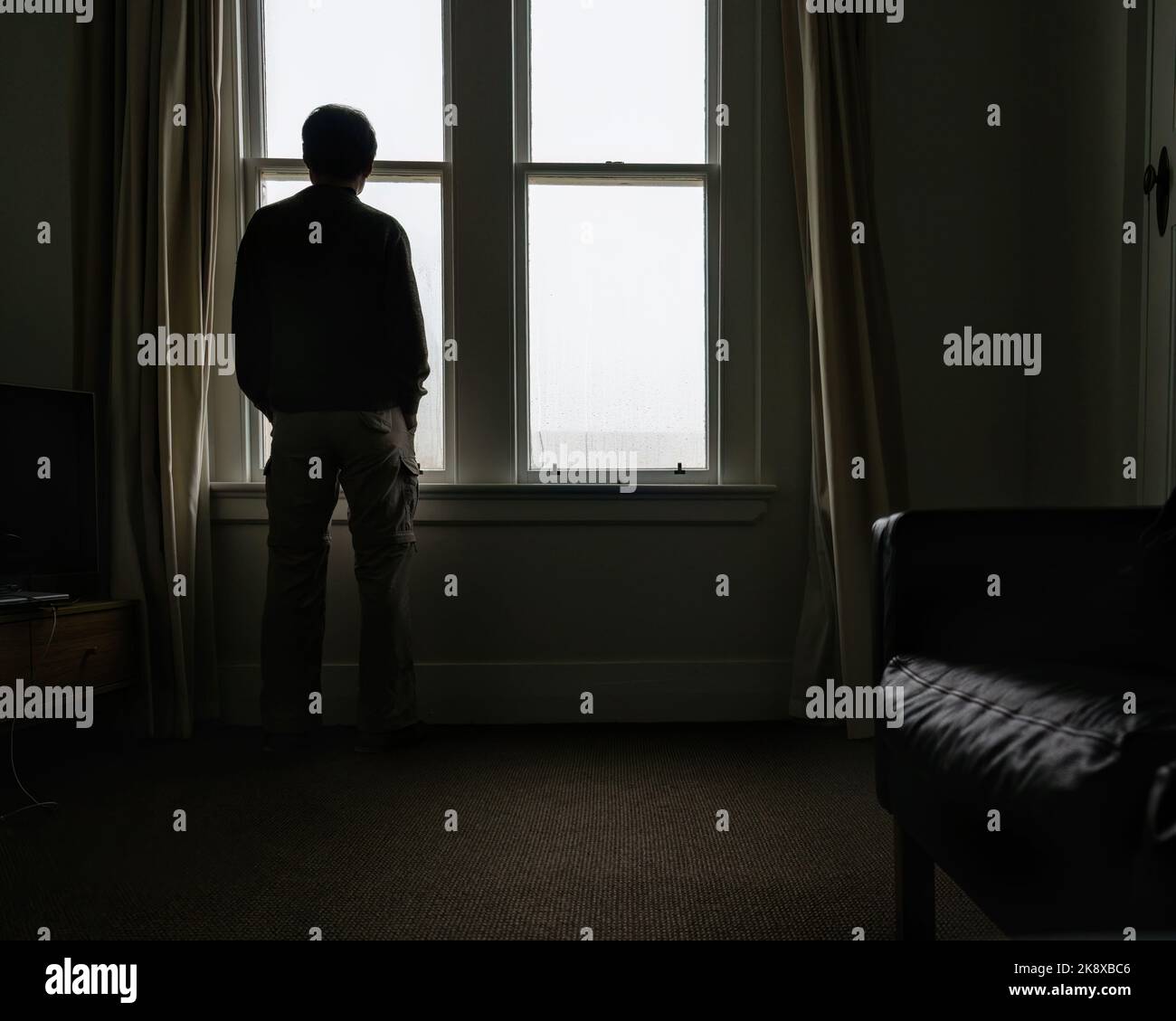 Man standing by the window with condensation, looking outside Stock ...