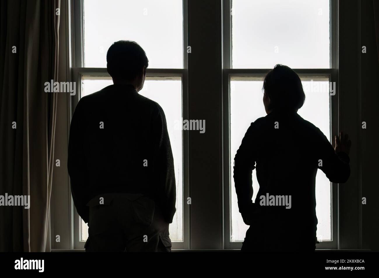 Couple standing by the window with condensation, looking outside Stock ...