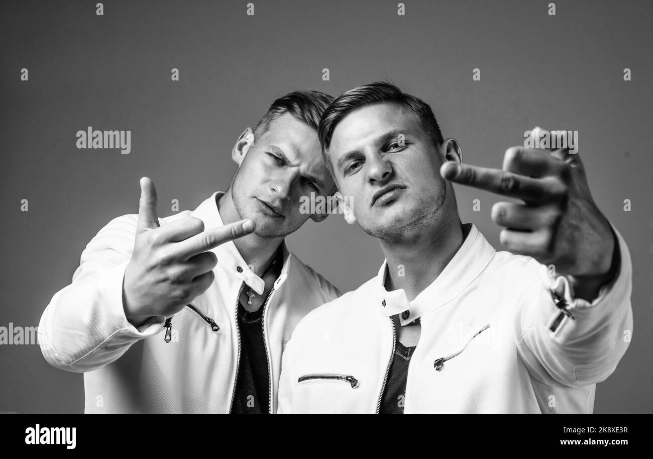 twin brothers men in white casual clothes look alike show middle finger ...