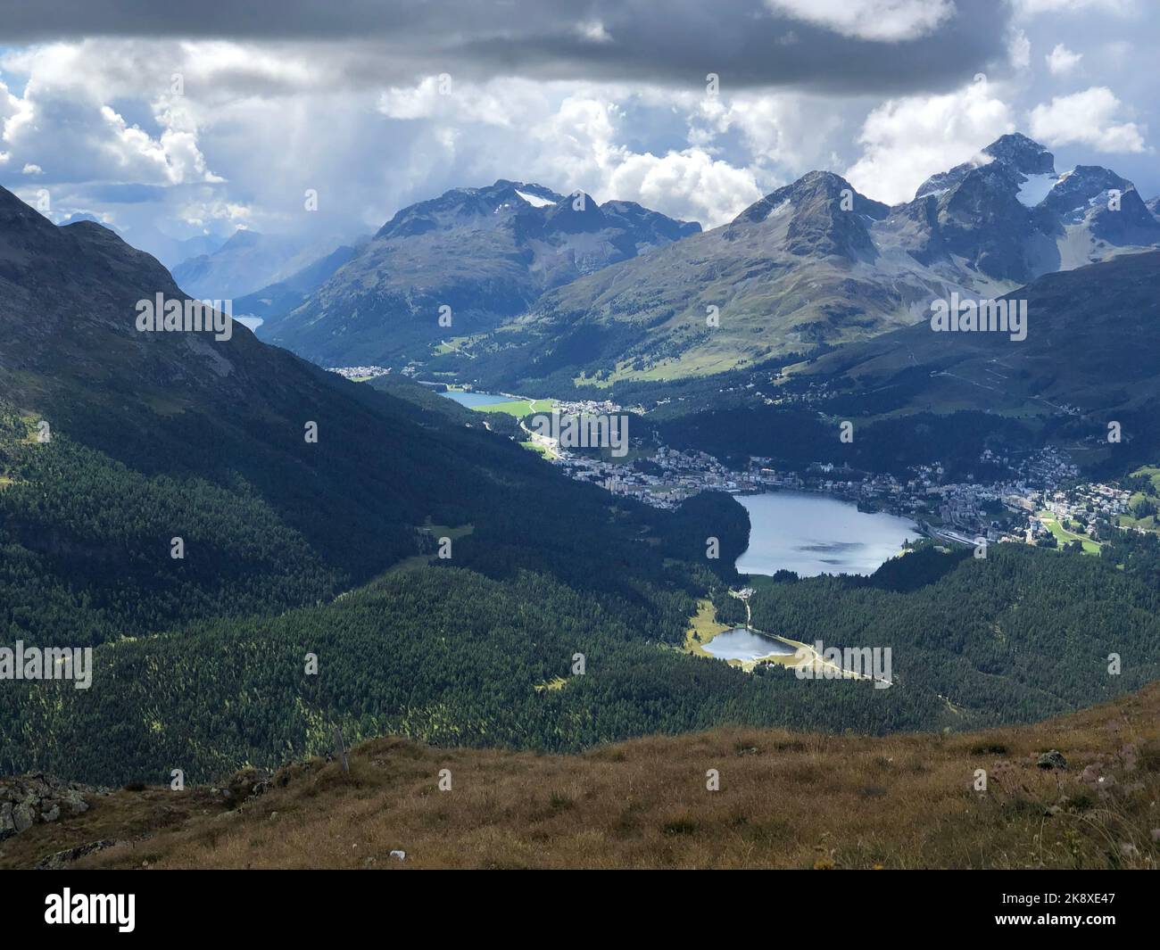 A landscape of range green hills over lake under dramatic cloudy sky in ...