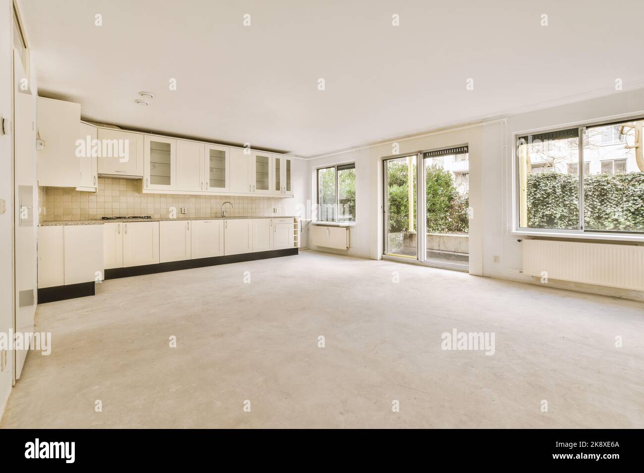 Interior of empty white kitchen with windows and wooden parquet floor ...