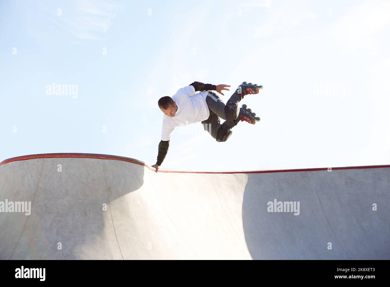 Energetic man on roller skates in motion at modern roller skate park ...