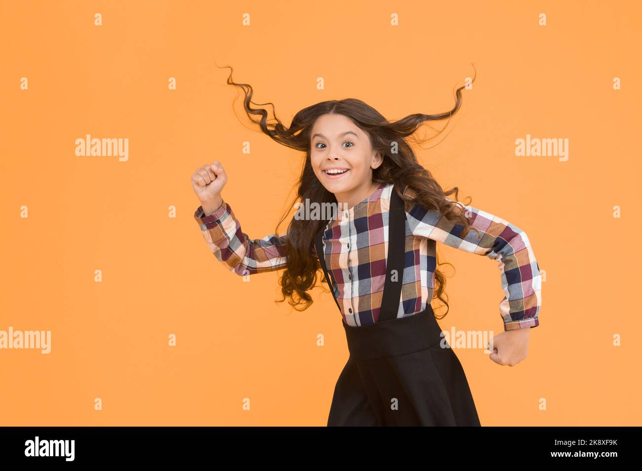 Make haste slowly. Energetic girl hurry to school. Small child wear ...