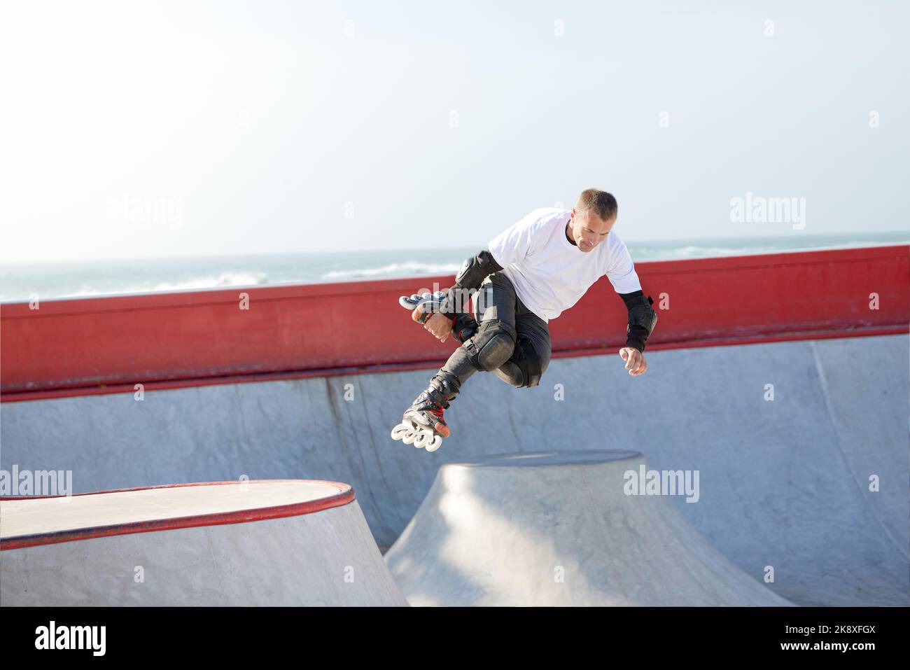 Energetic man on roller skates in motion at modern roller skate park ...