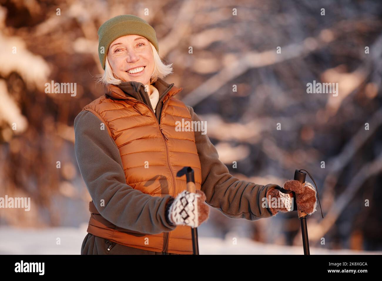 Waist up portrait of smiling mature woman enjoying Nordic walk in ...