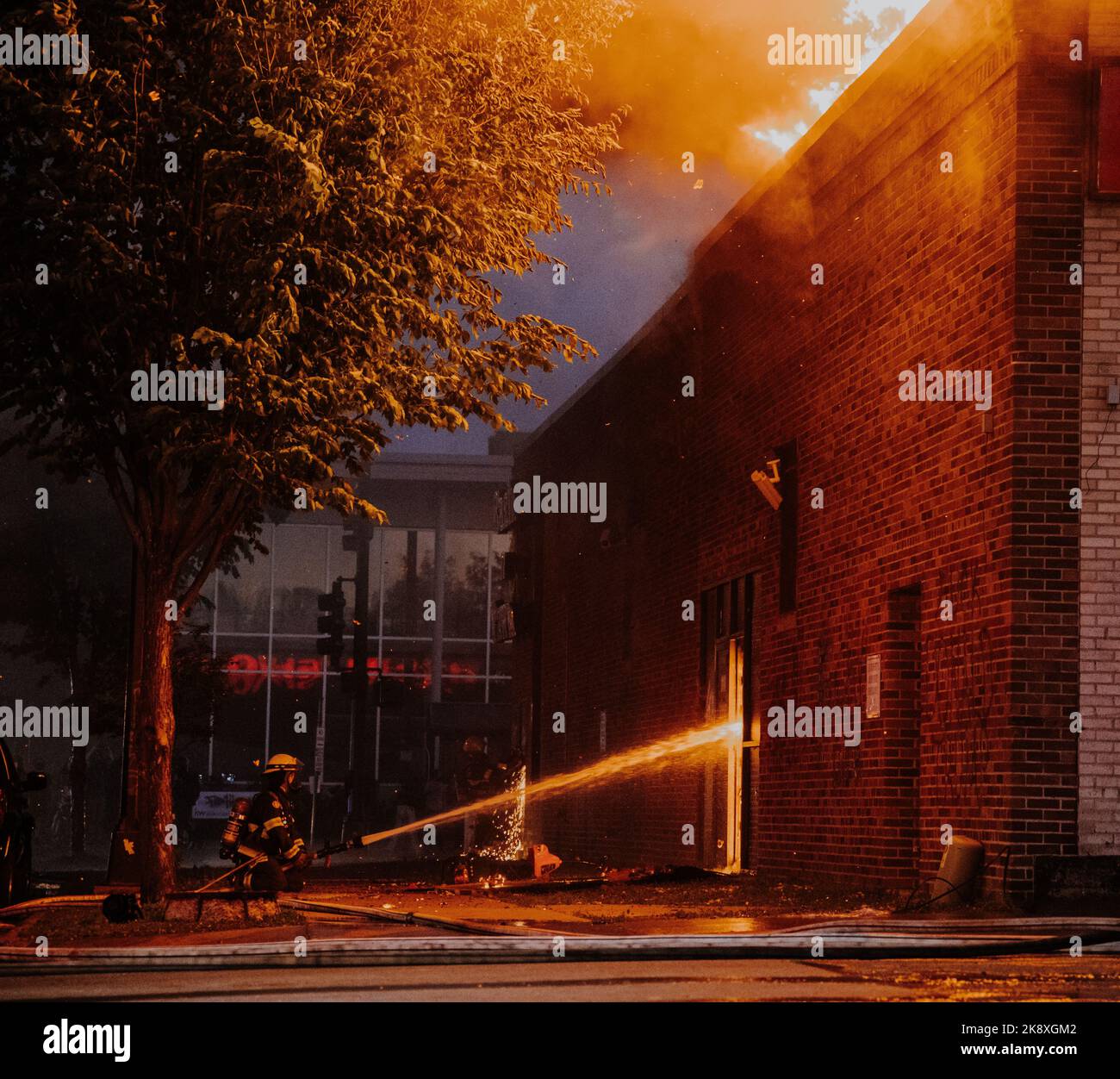 A firefighter extinguishing a fire during the George Floyd Riots of ...