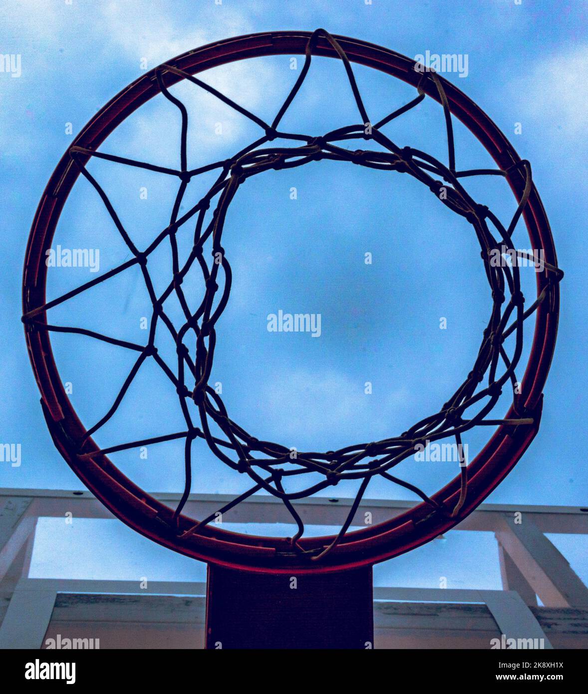 A low angle shot of a basketball hoop under the blu cloudy sky Stock ...