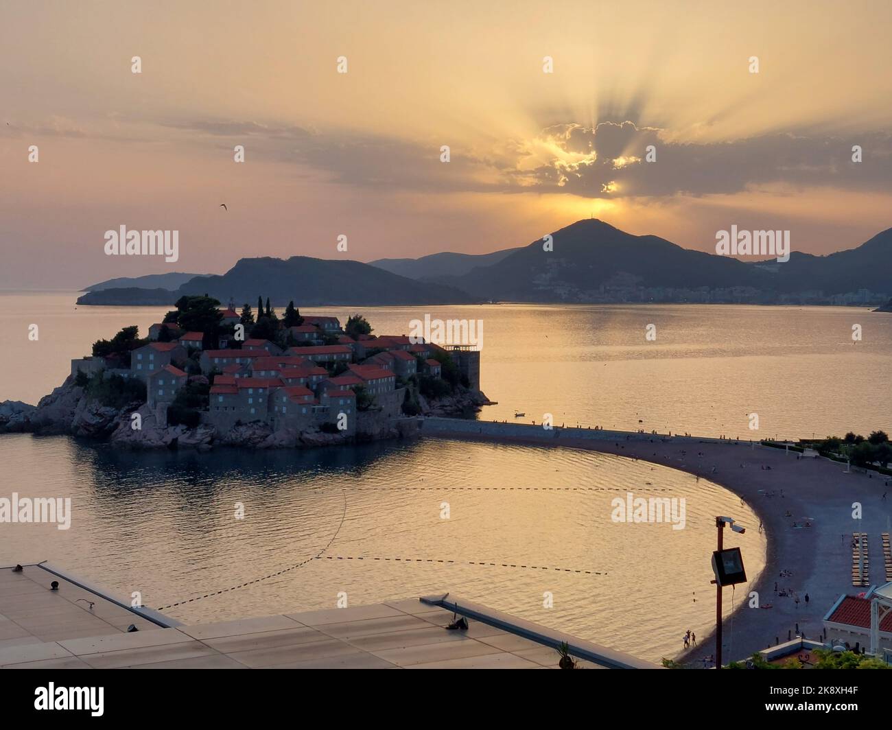 A beautiful aerial scene of Sveti Stefan island under sunset sky in ...