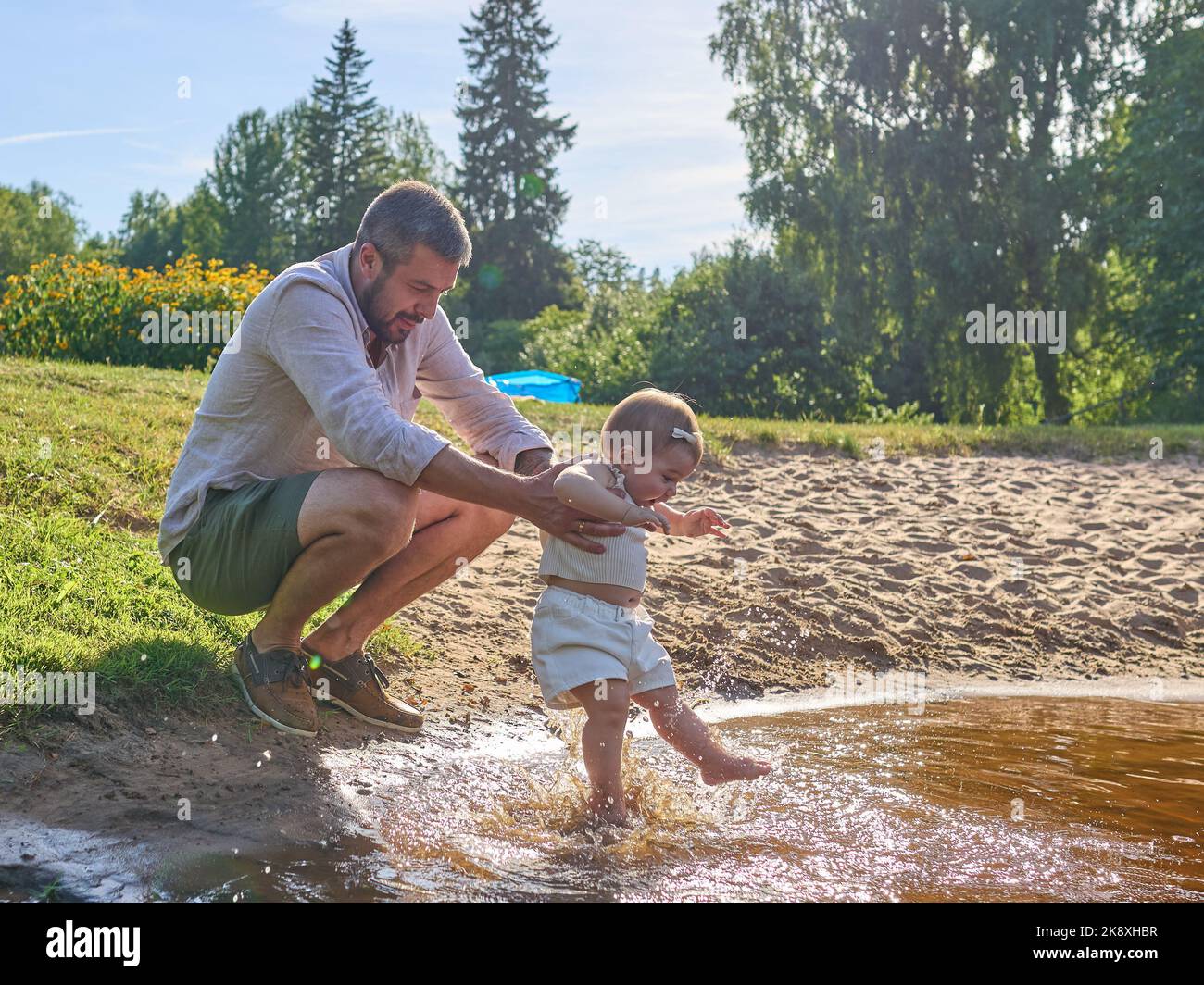 A dad and daughter having fun on the lake shore Stock Photo - Alamy