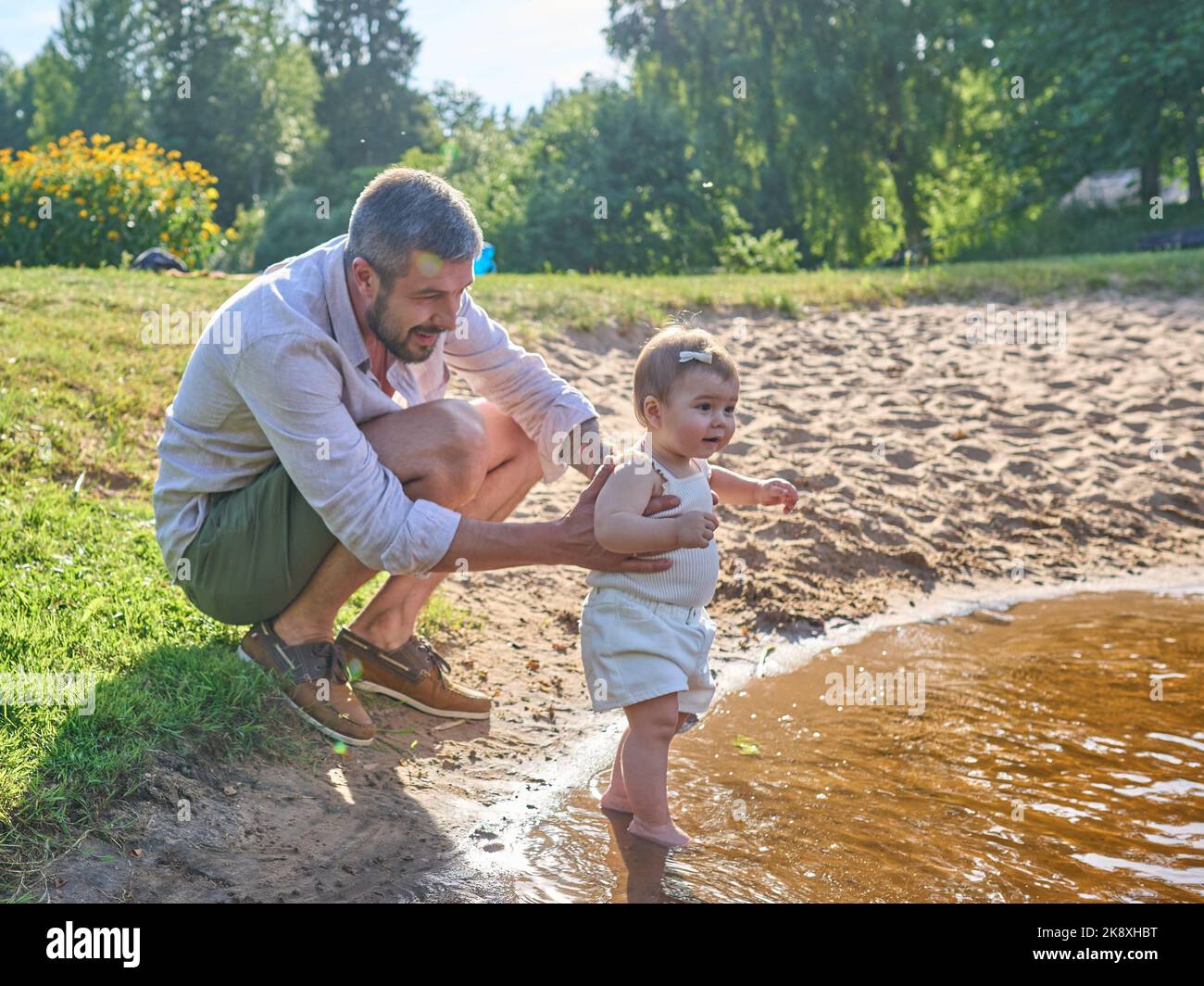 A dad and daughter having fun on the lake shore Stock Photo - Alamy