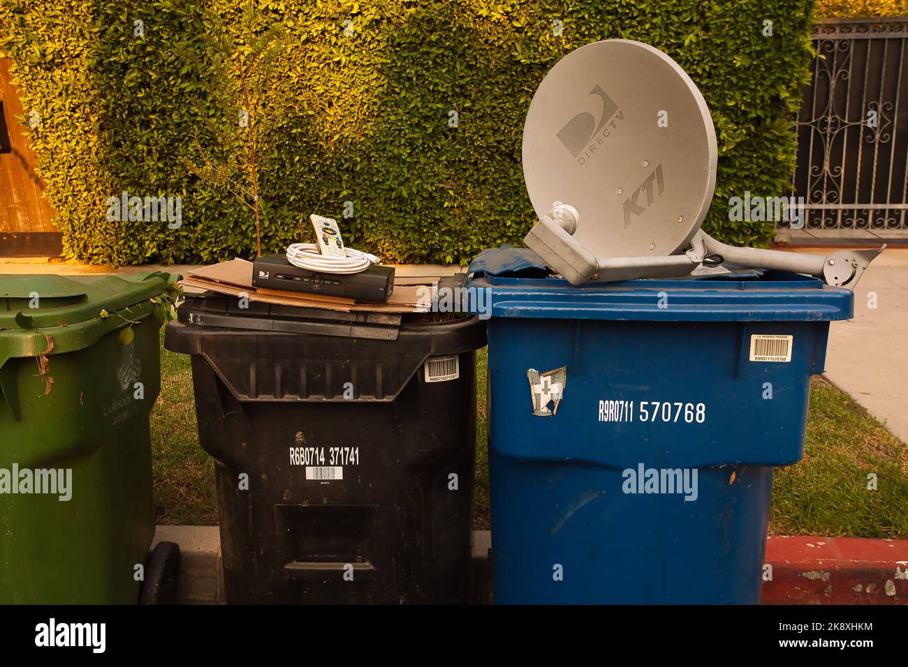 Satellite dish and receiver in curbside garbage containers Stock Photo ...