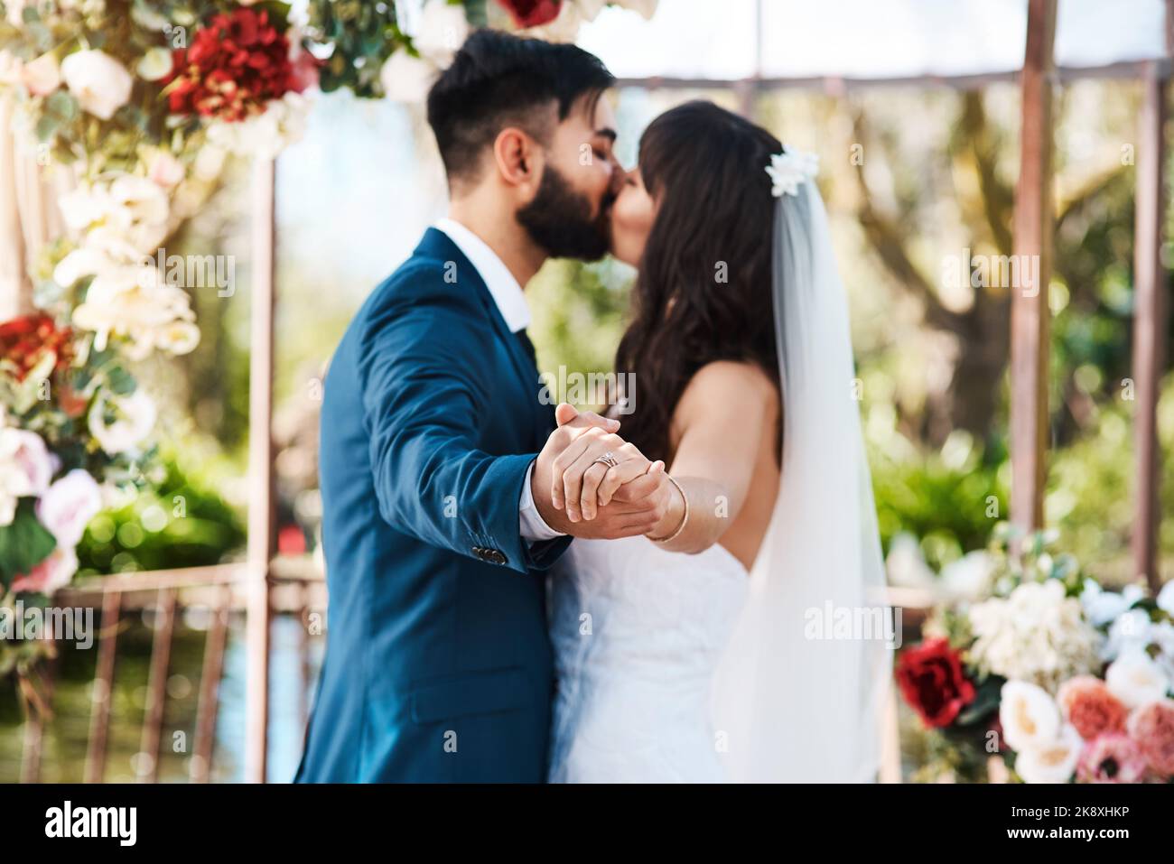 They chose to spend their forever together. an unrecognizable newlywed couple kissing while ...