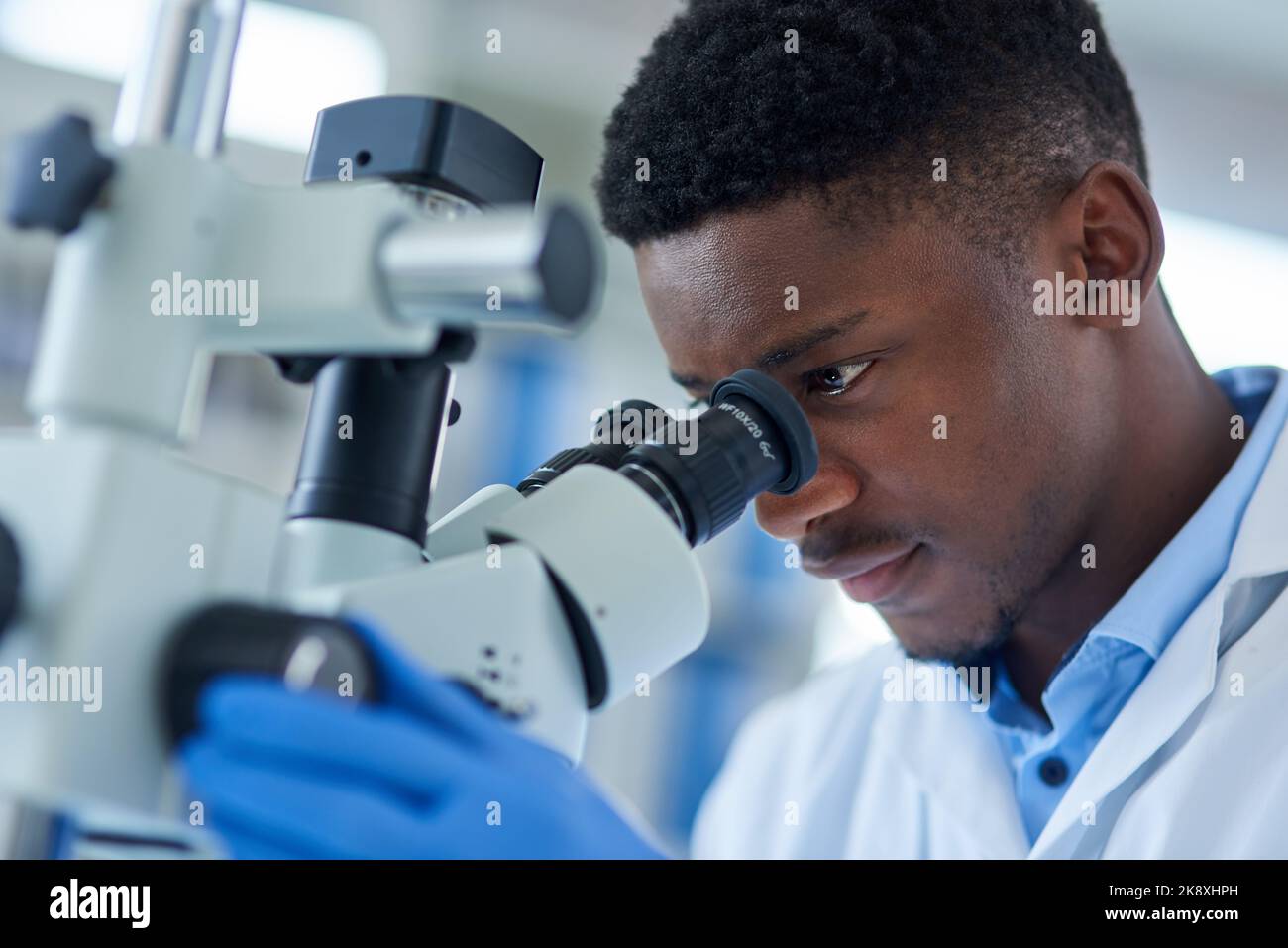 Working hard all day. a focused young male scientist looking at test ...