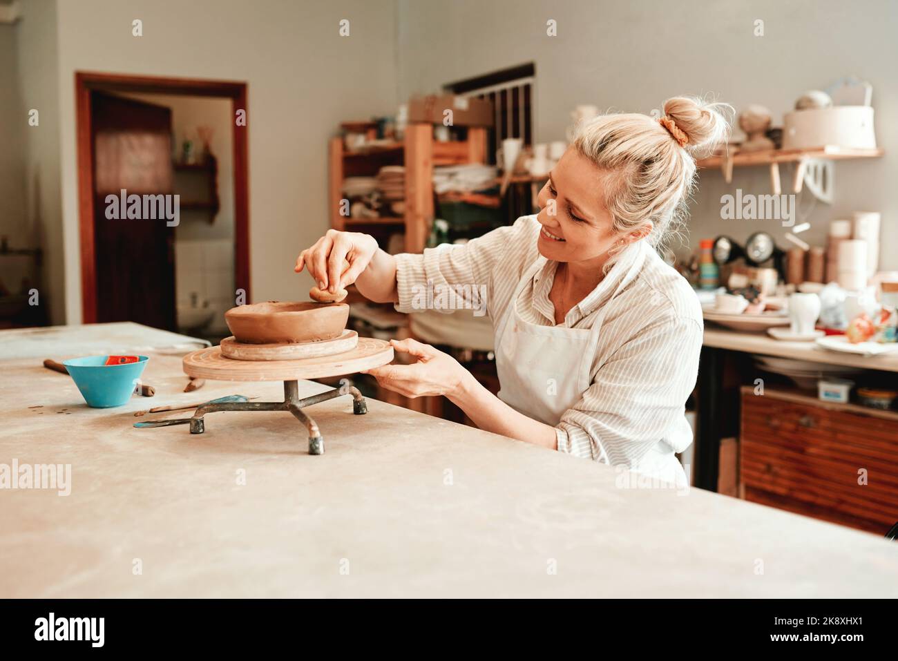 I love pottery and everything about it. a woman shaping a clay pot in ...