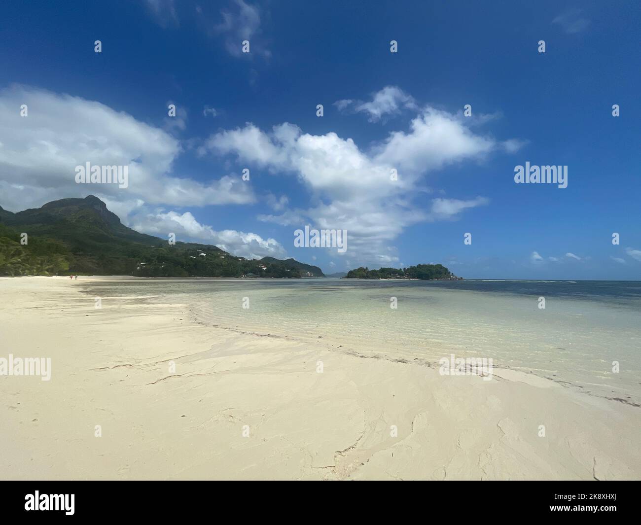 A beach in the Seychelles with silky smooth sand and shallow waves by ...