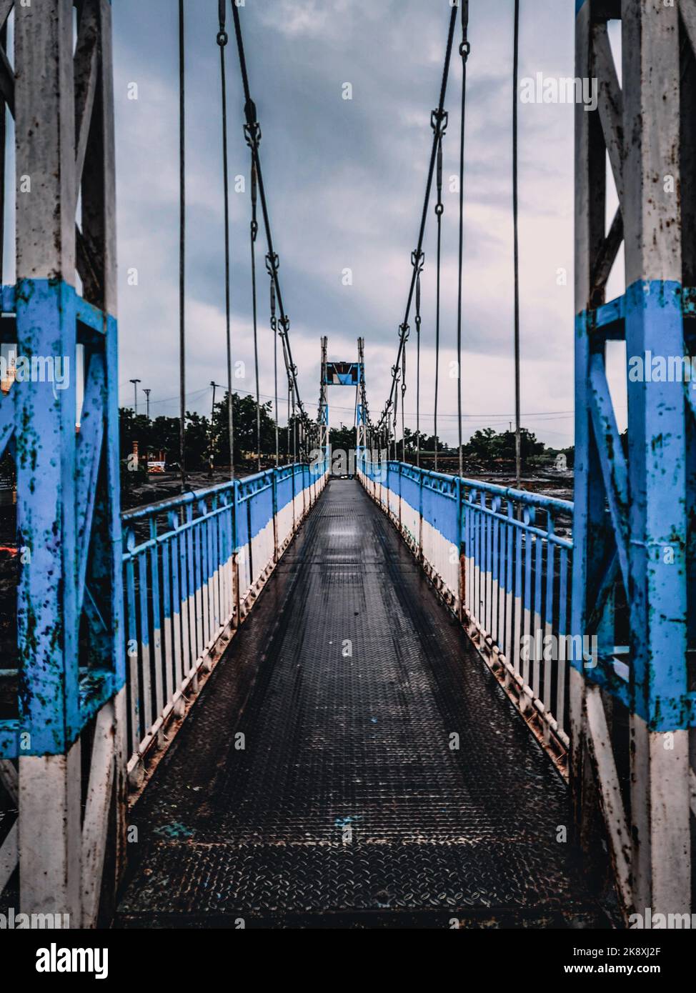 A vertical shot of a wet metallic bridge Stock Photo - Alamy