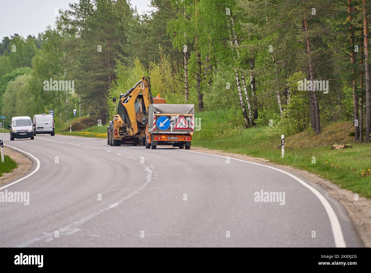 A heavy excavator and special road repair car with signs Stock Photo ...