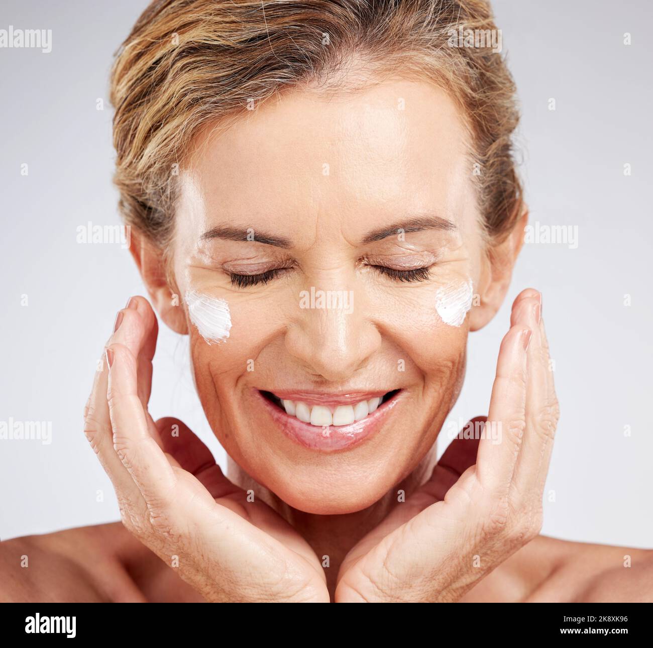 Mature woman, face cream and grooming skincare routine on studio ...