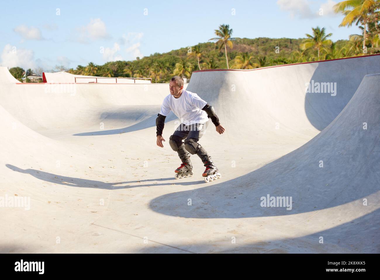 Mature male inline roller training in public skate park. Practicing ...