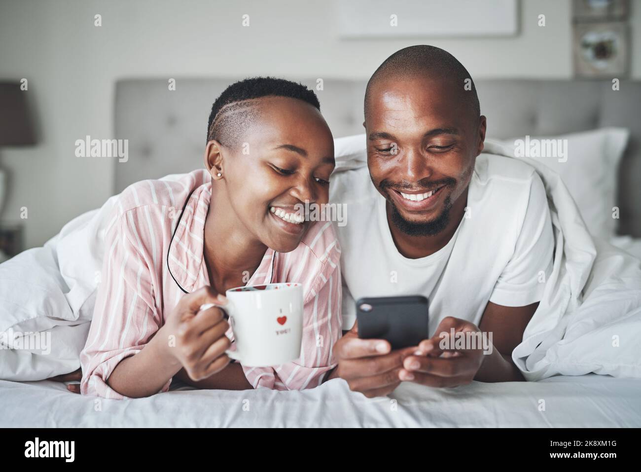 Nothing connects us like sharing things in common. a happy young couple using a smartphone and ...