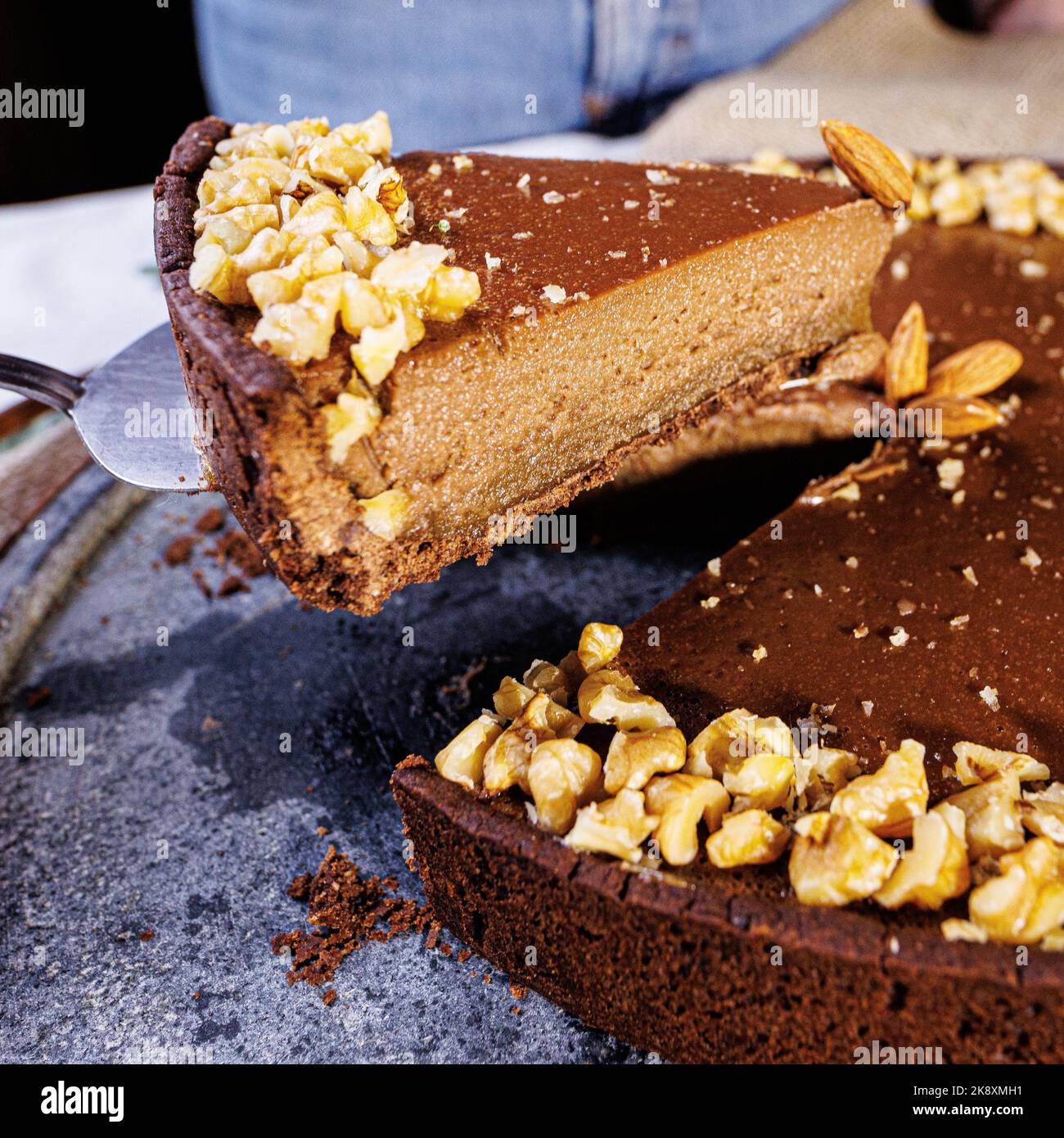 A piece of chocolate cake covered by nuts, close-up Stock Photo - Alamy