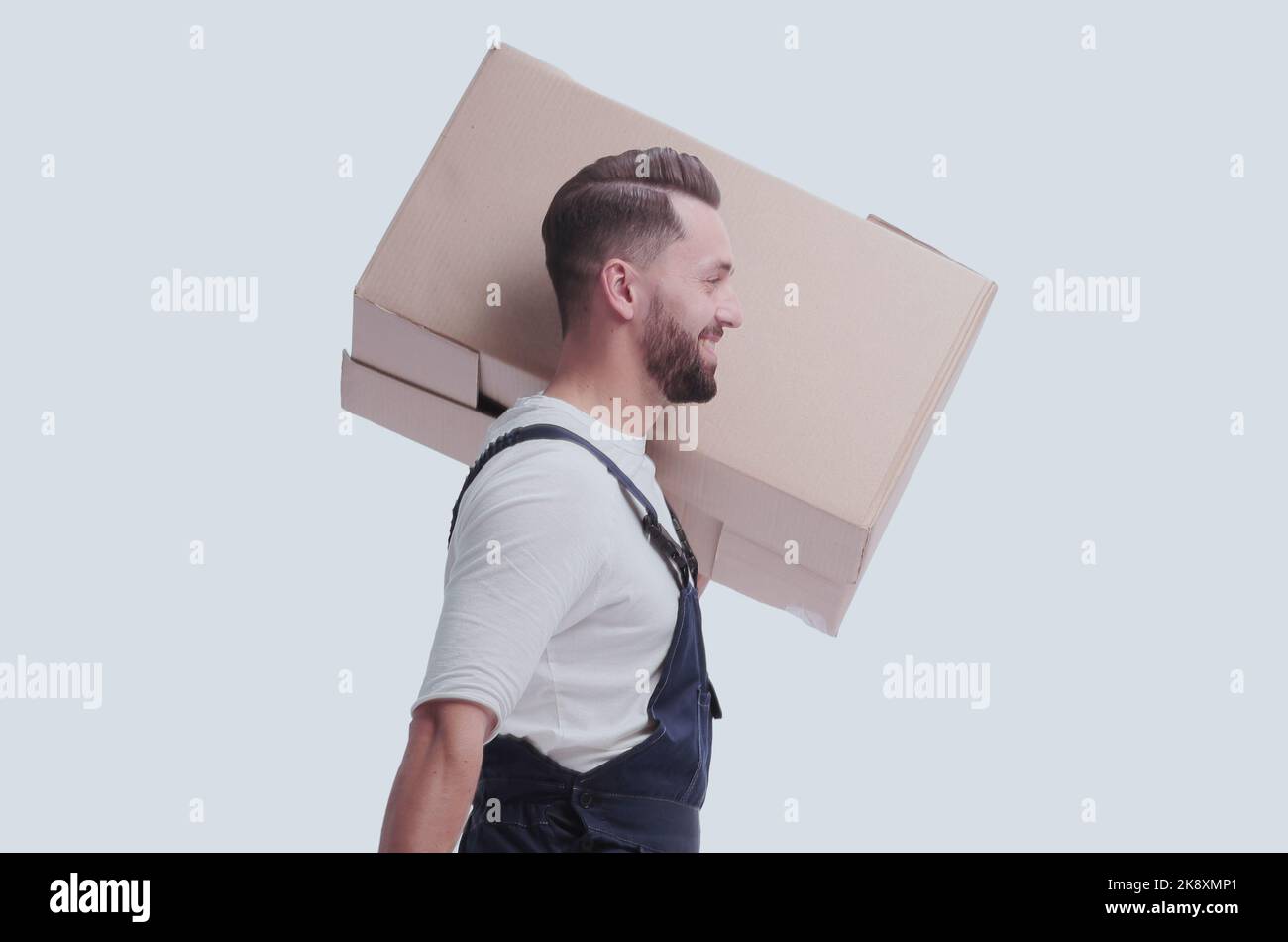 side view. a man in overalls carries a large cardboard box Stock Photo ...
