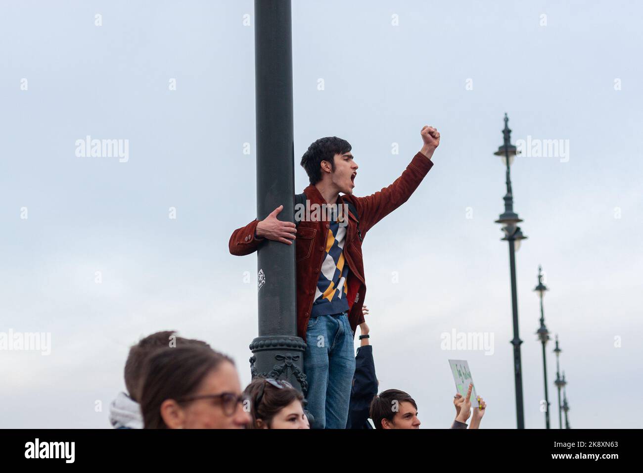 A closeup shot of a teenager shouting at a protest while holding onto a ...