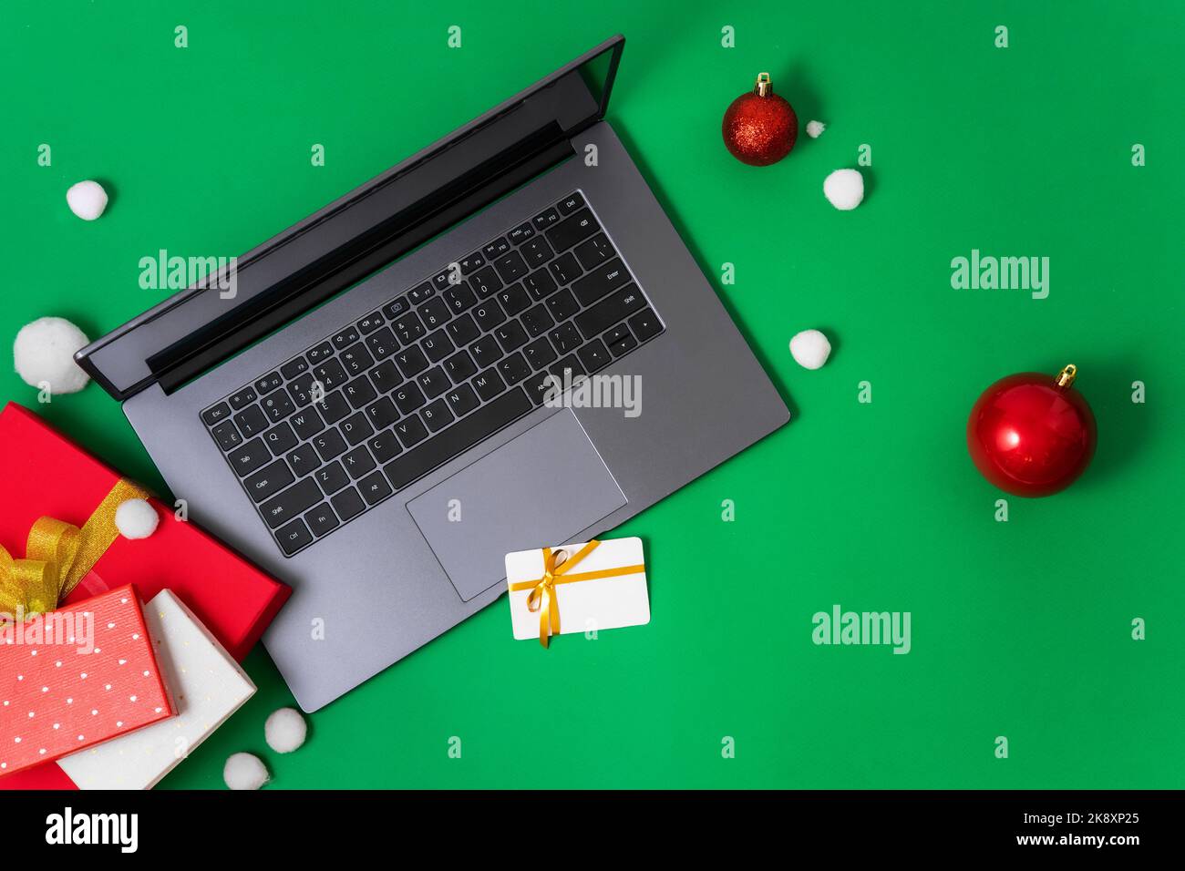 Flat lay, laptop, gift boxes, gift certificate, bonus card on green ...