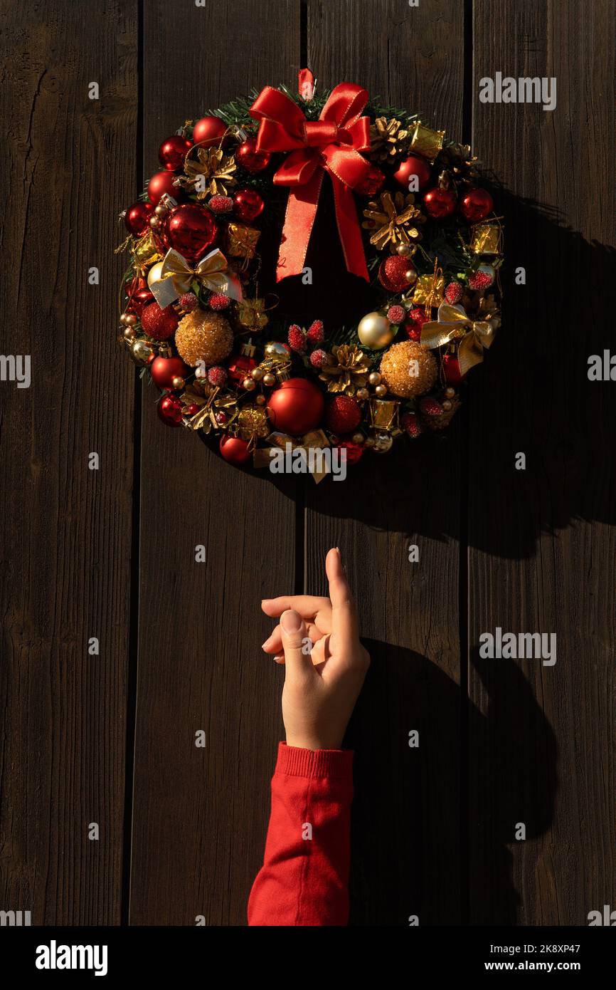 Stylish festive background with Christmas wreath and female hand ...