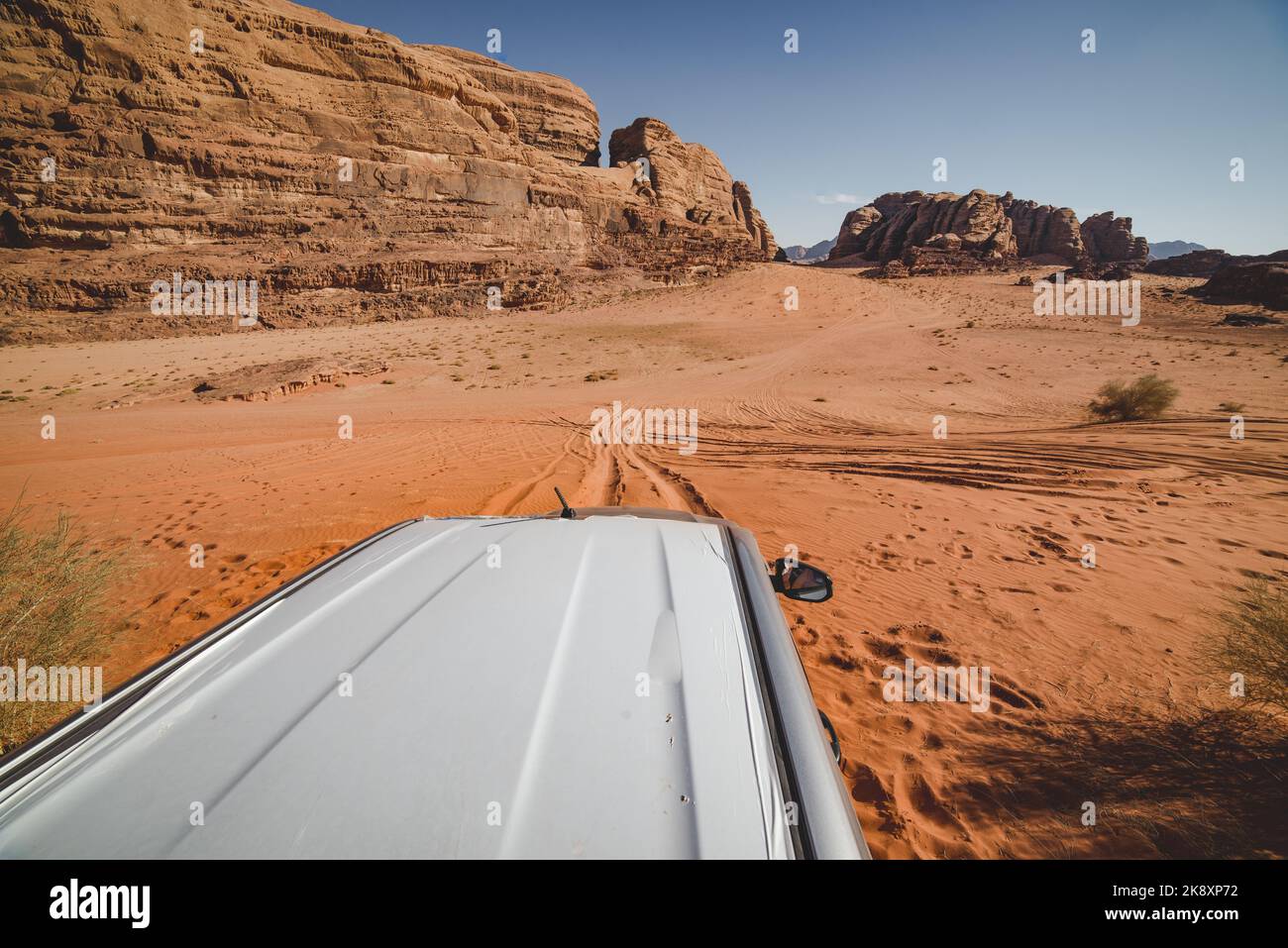 A silver car in the desert with red canyons under the clear sky Stock ...