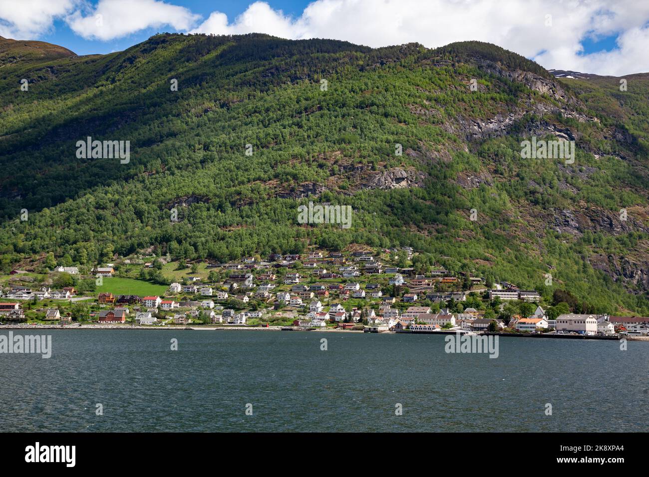 A Narrow Fjord surrounded by mountains covered with historical village ...