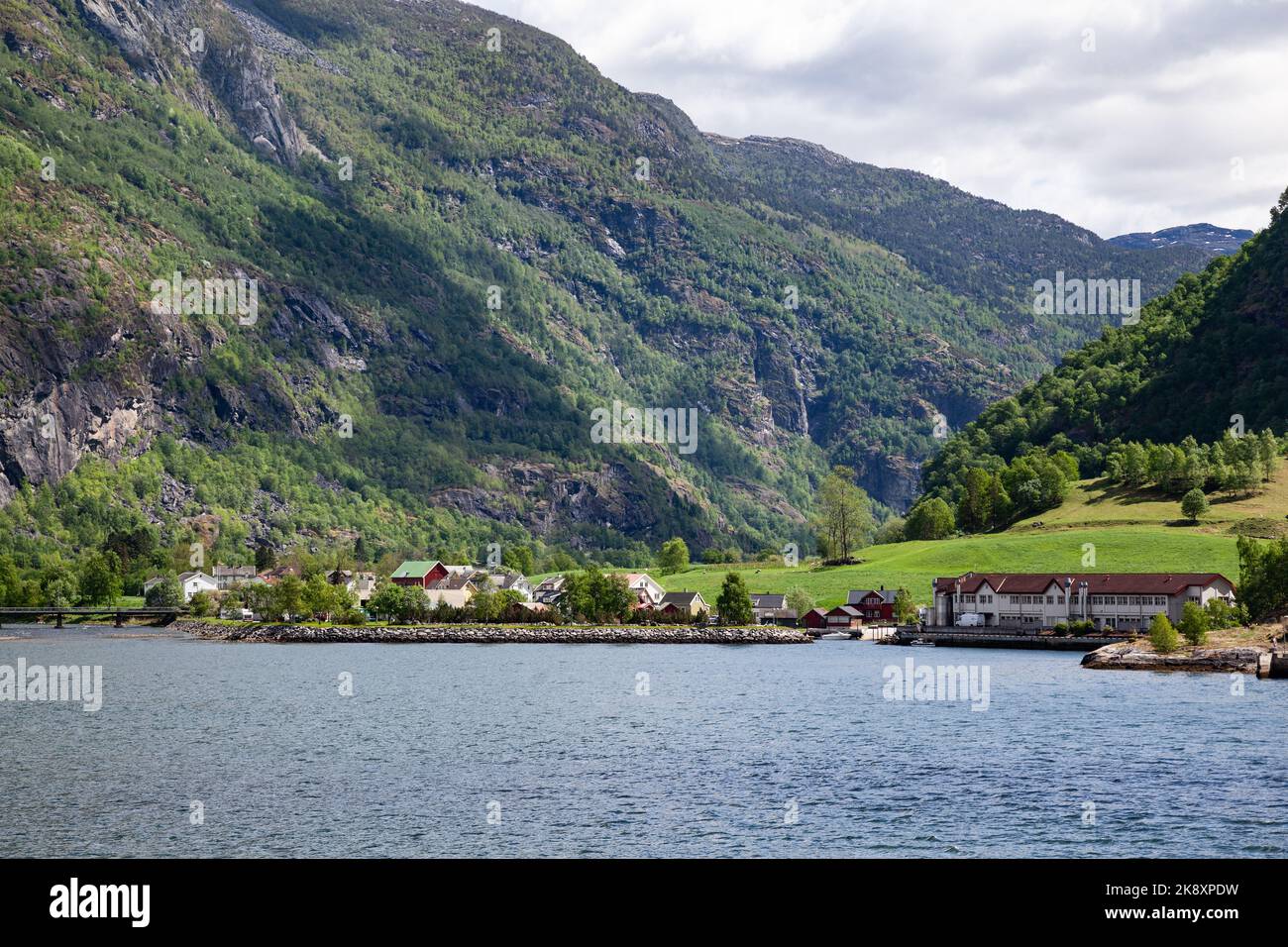 A Narrow Fjord surrounded by mountains covered with historical village ...