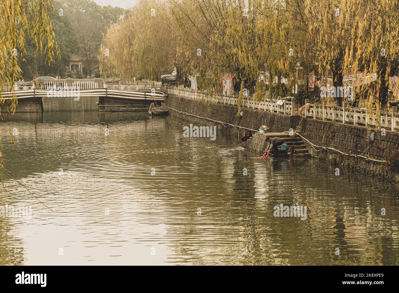 A woman doing laundry in a river flowing through Ningbo, China Stock ...