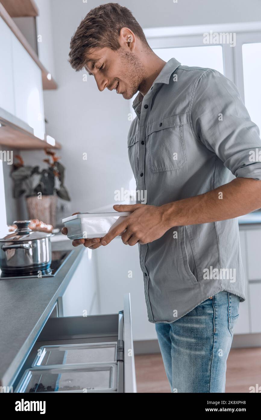 close up. a smiling man looks into a pot of food Stock Photo - Alamy