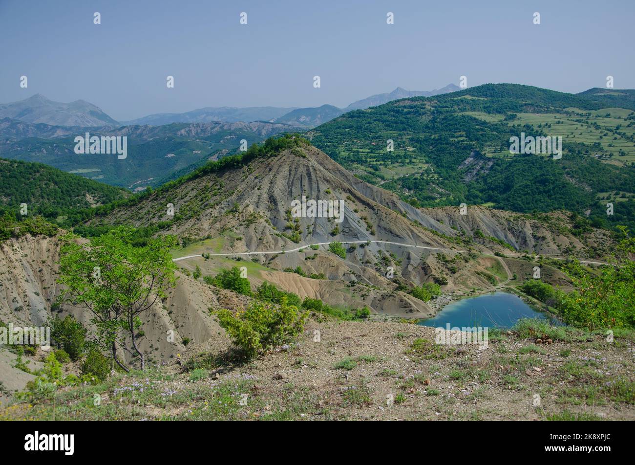 An aerial shot of a mountain range covered with green plants with a ...