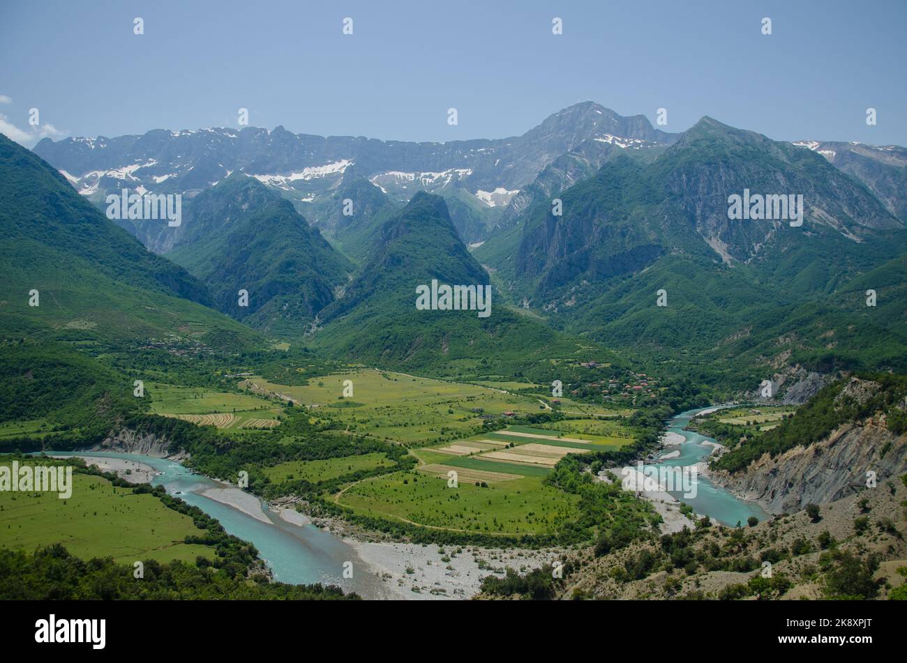 An aerial shot of a mountain range covered with green plants with a ...
