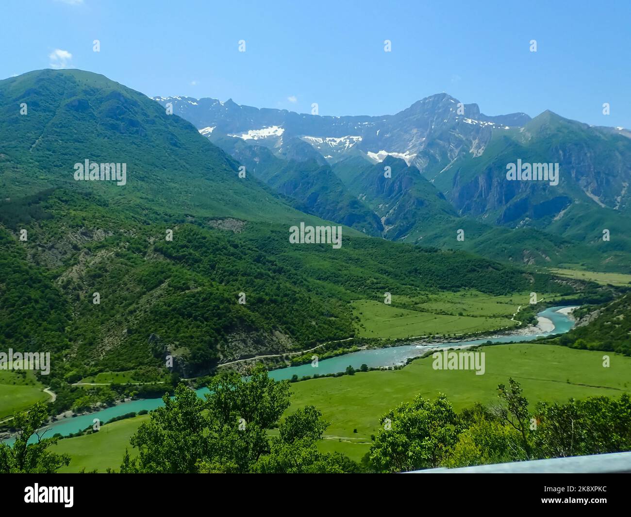 An aerial shot of a mountain range covered with green plants with a ...