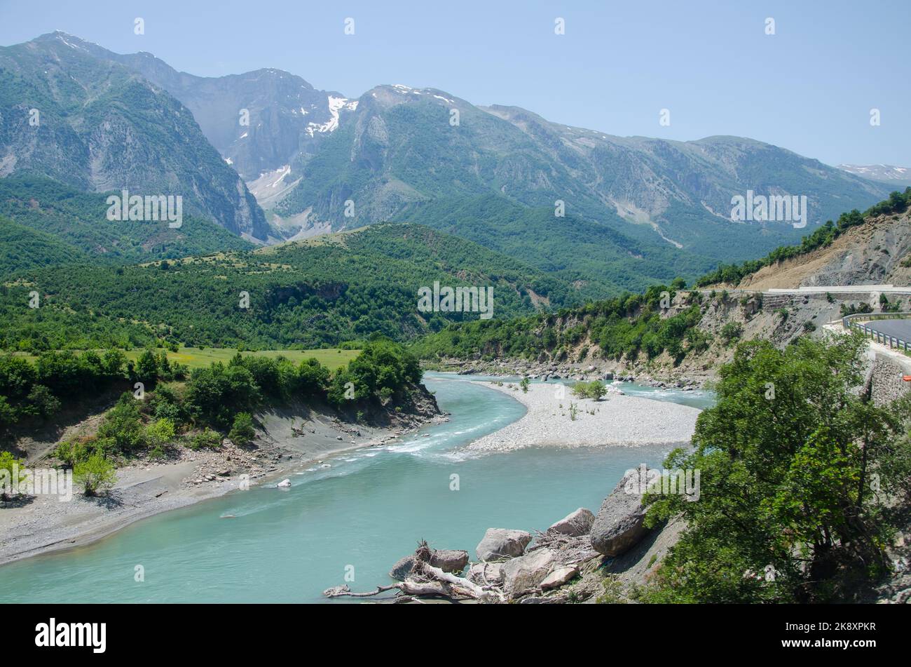 An aerial shot of a mountain range covered with green plants with a ...