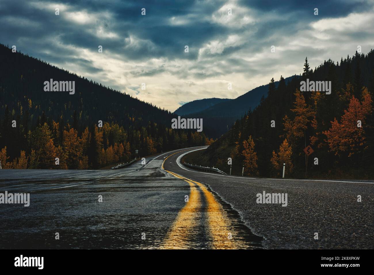 A low angle shot of an empty highway road surrounded by a mountain ...