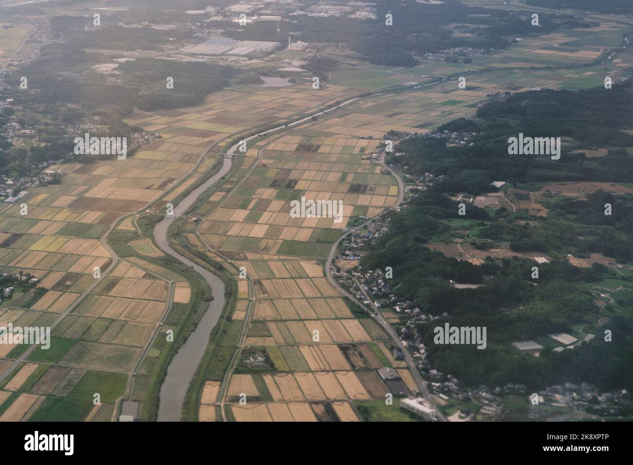 An aerial shot from the aircraft over the Japanese fields and a river ...