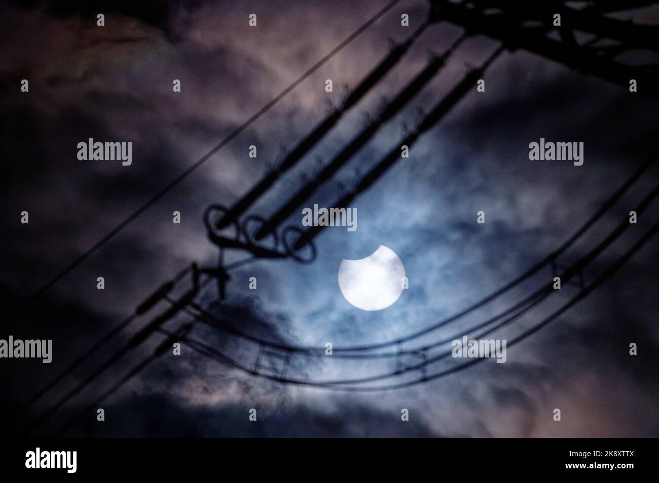 Cologne, Germany. 25th Oct, 2022. The sun eclipsed by the moon shines ...