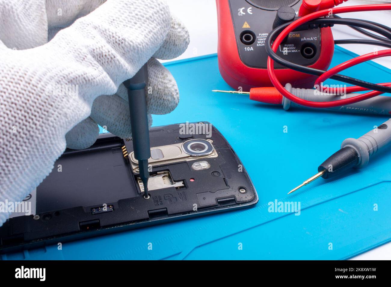Mobile phone repair. The service technician disassembles the phone on ...