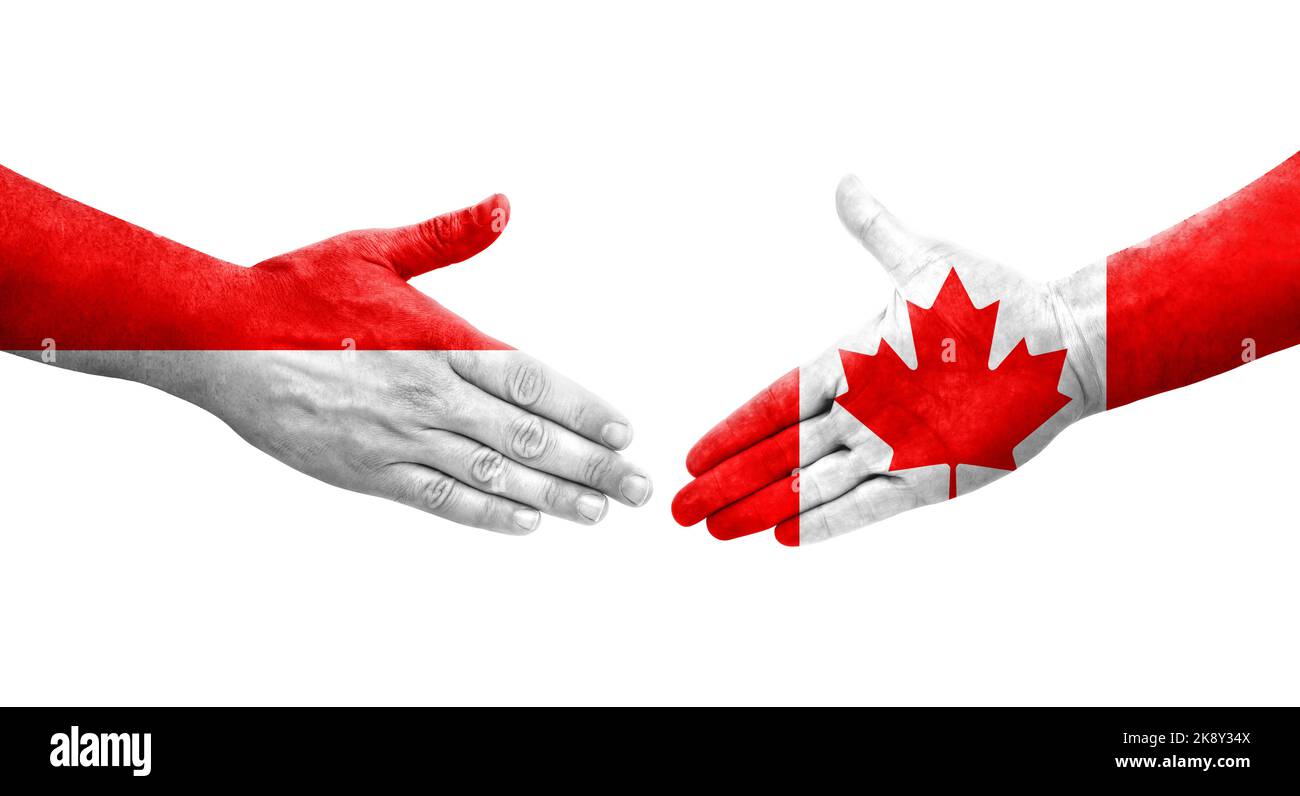 Handshake between Canada and Indonesia flags painted on hands, isolated ...