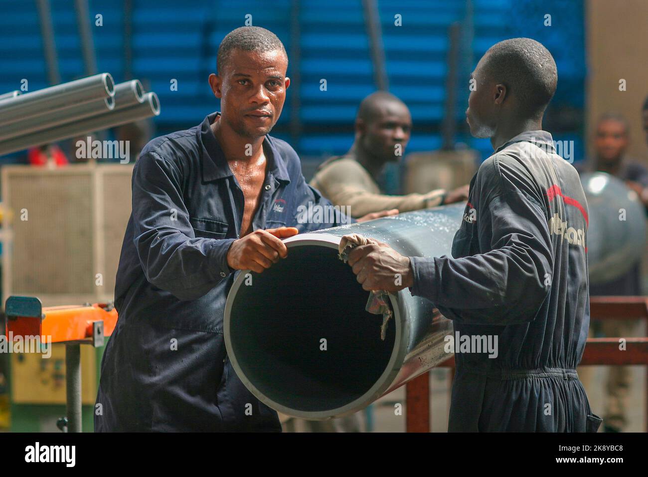 Ghana, Accra. Factory workers of Interplast Factory producing PVC pipes ...