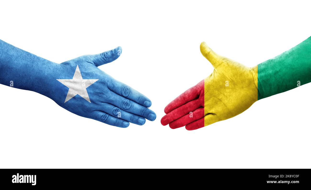 Handshake between Guinea and Somalia flags painted on hands, isolated ...