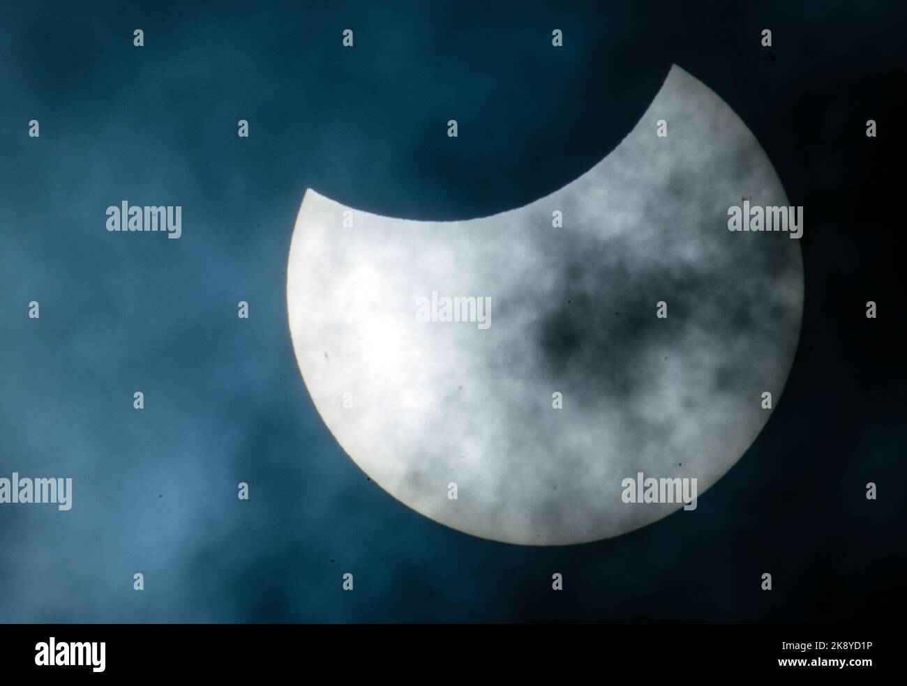 Schwerin, Germany. 25th Oct, 2022. A partial solar eclipse can be seen behind dense clouds. In ...