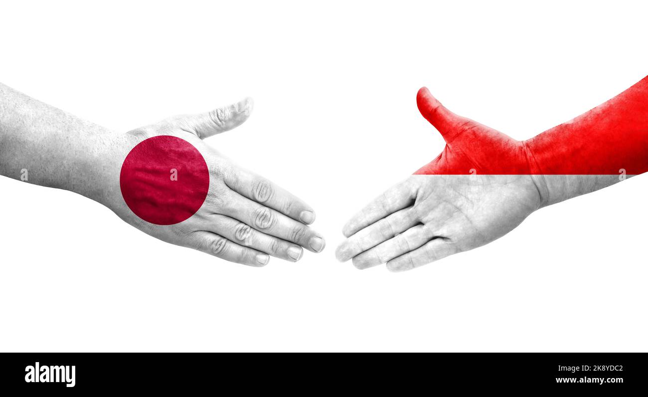 Handshake between Indonesia and Japan flags painted on hands, isolated ...