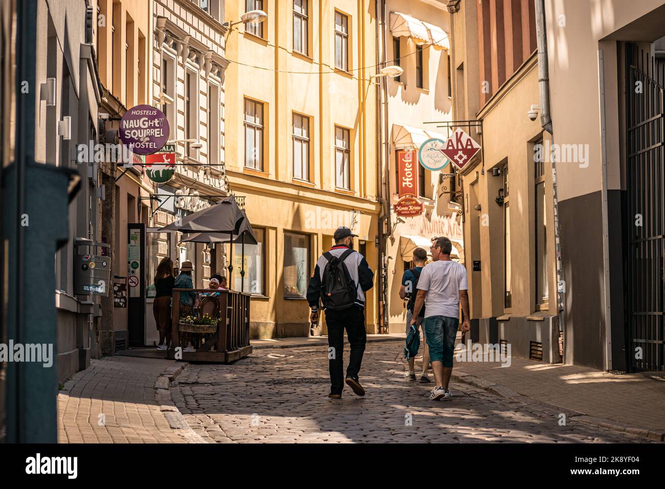 A beautiful shot of people walking on a narrow street between buildings ...