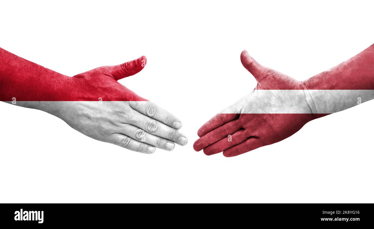 Handshake between Latvia and Monaco flags painted on hands, isolated ...