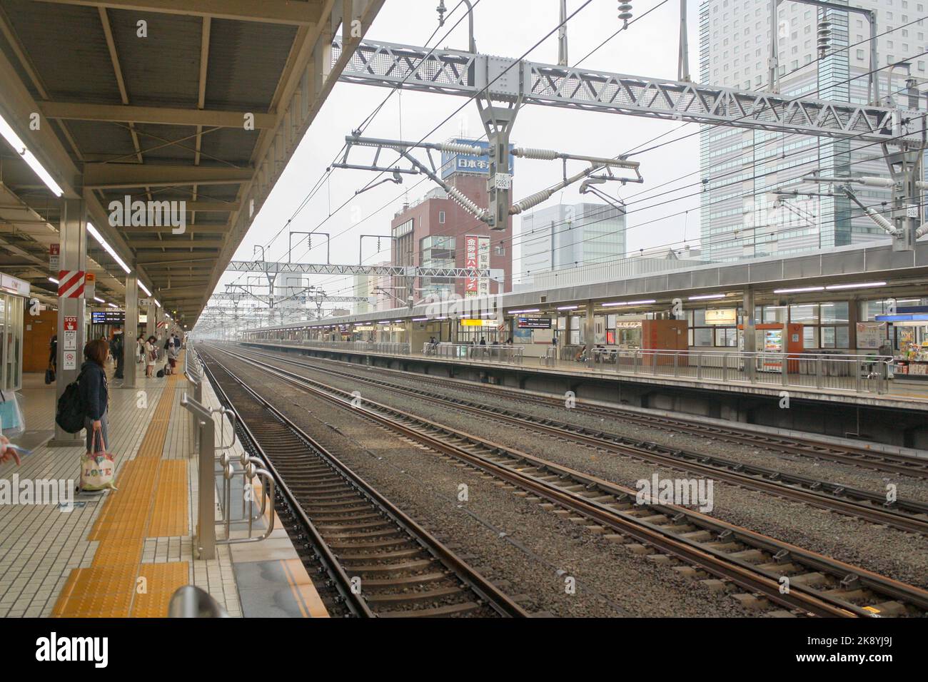 View of empty shinkansen track and crowd of people standing and waiting ...